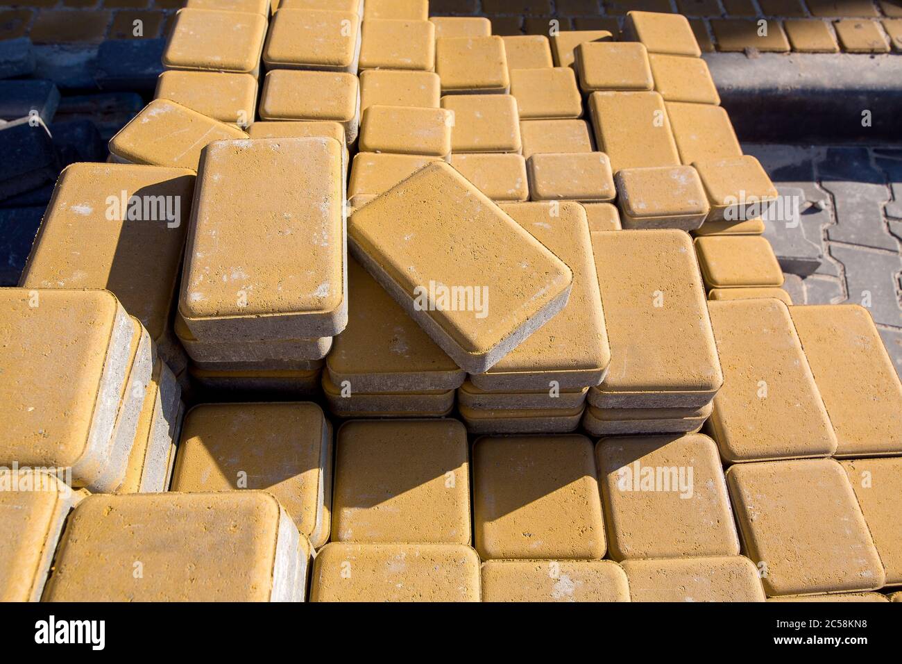 New yellow paving slabs piled in a heap one on top of another, top view ...