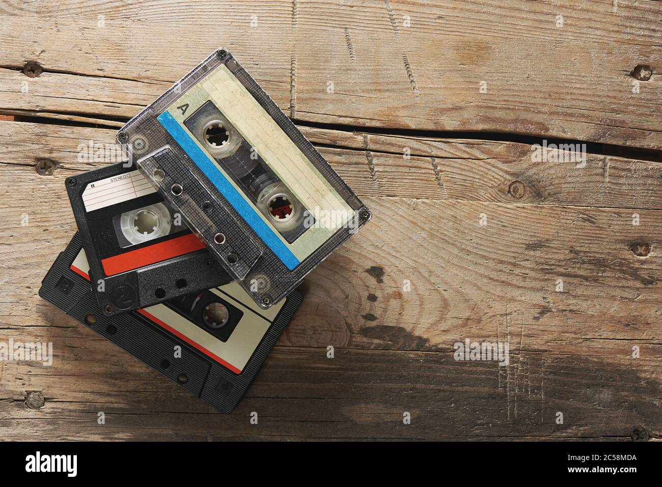 Old audio tape compact cassettes on wooden background. top view with ...