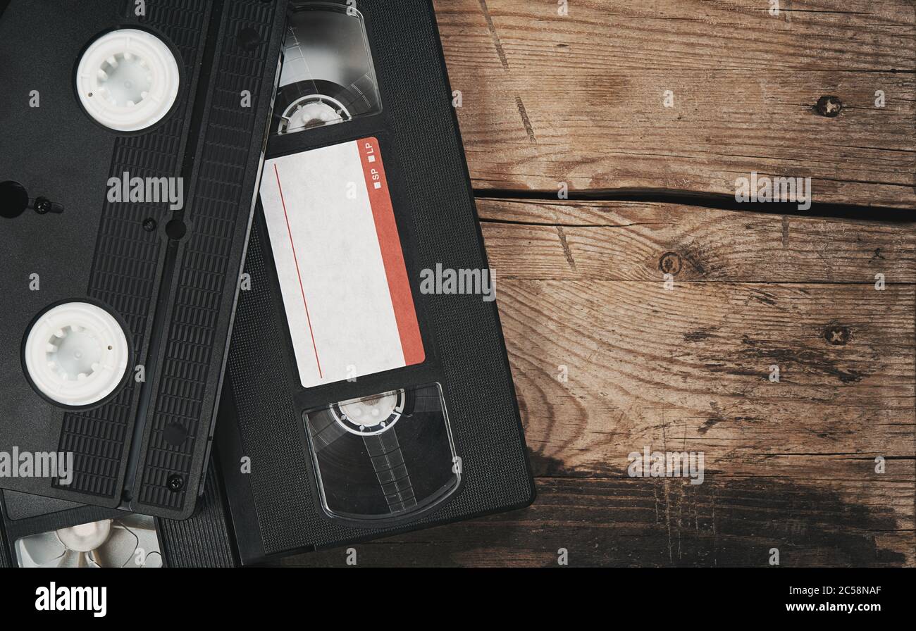 stack of VHS video tape cassettes over wooden background. Top view ...