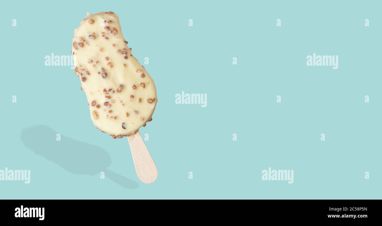 White chocolate ice cream bar popsicle with nuts isolated on blue ...