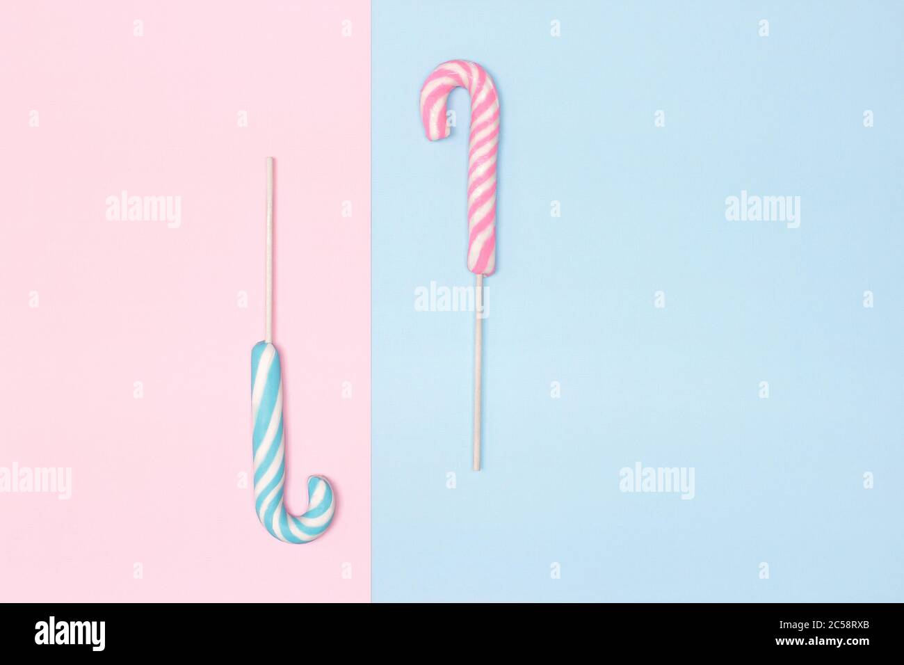 Two candy canes on pastel blue and pink background. Minimalistic ...