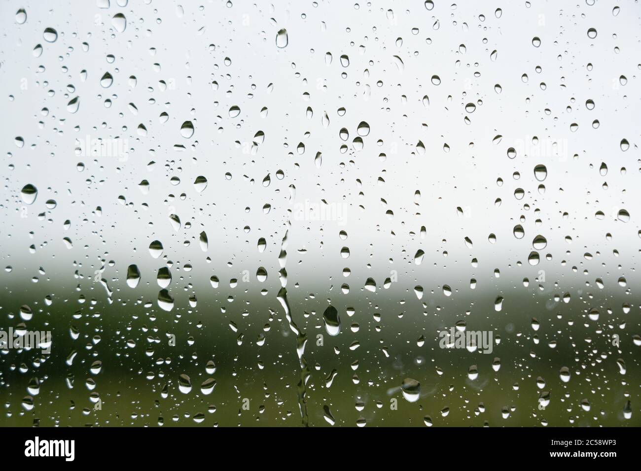 Raindrops on window with out of focus background. Hertfordshire. UK ...
