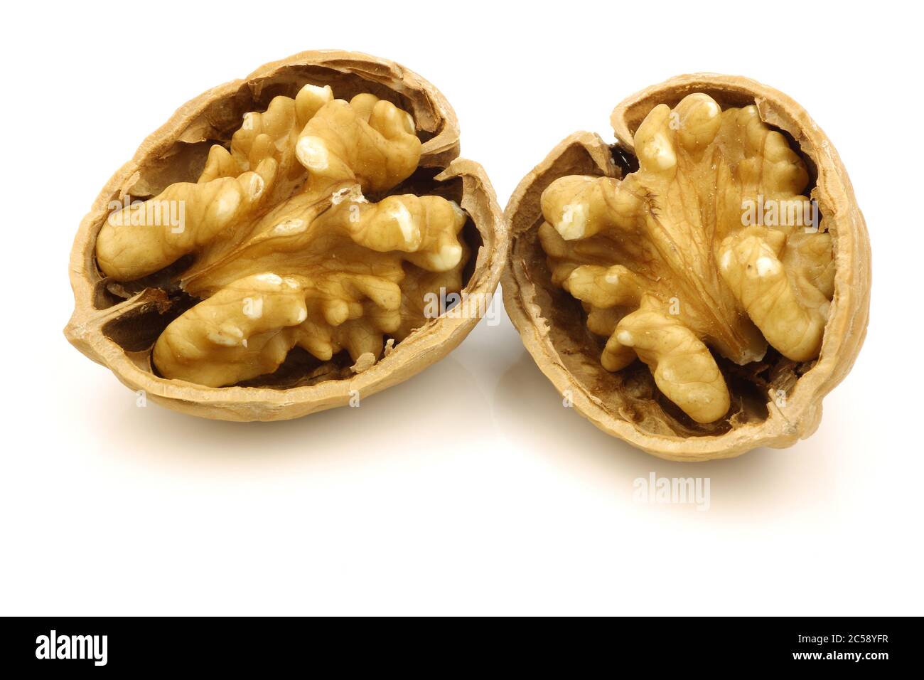 Two cracked and opened walnut halves on a white background Stock Photo ...