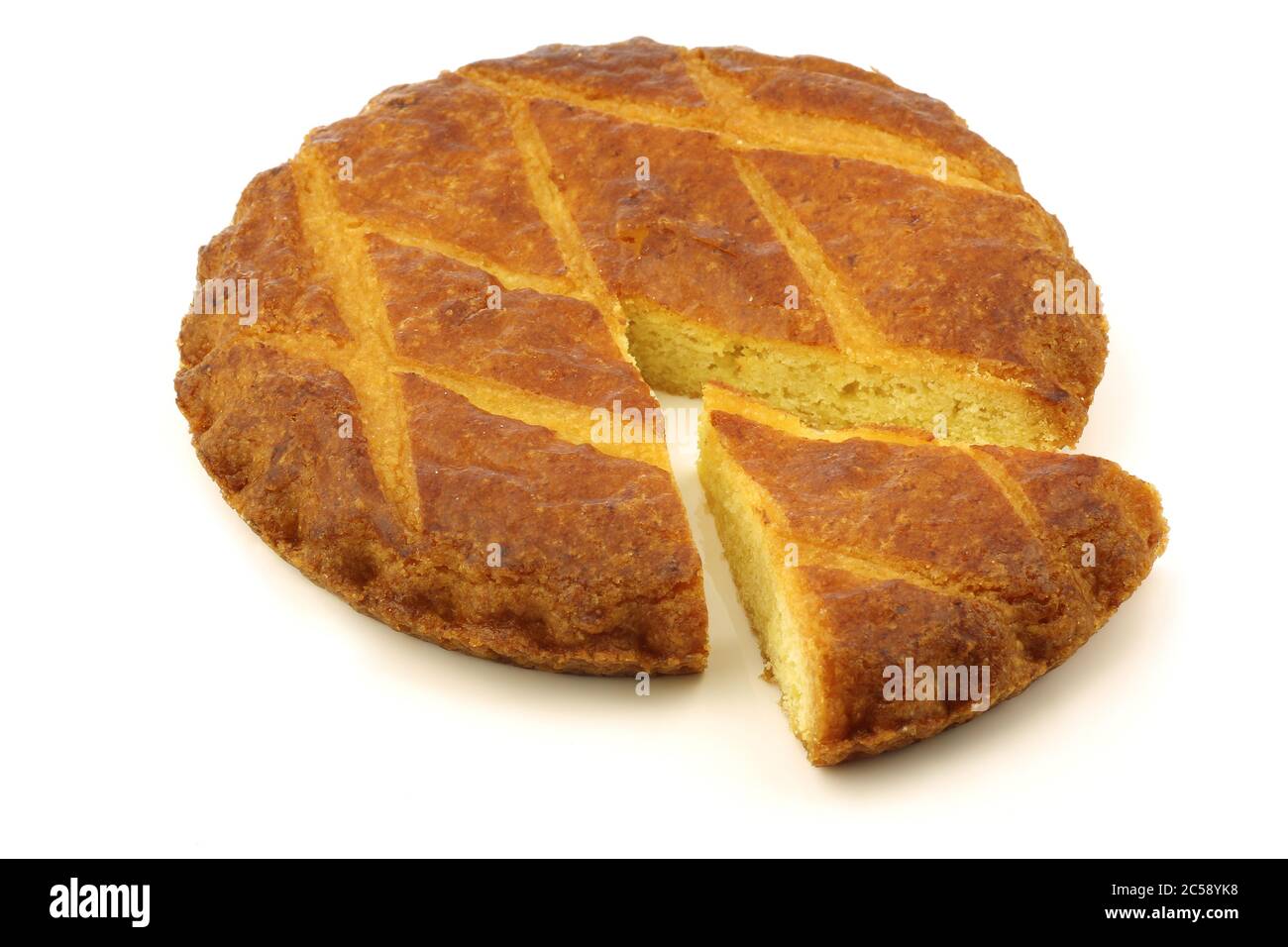 traditional Dutch cake called "boterkoek" and a cut slice on a white ...