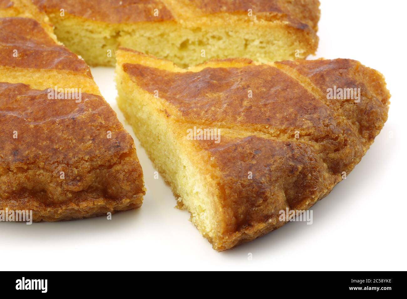 traditional Dutch cake called "boterkoek" and a cut slice on a white ...