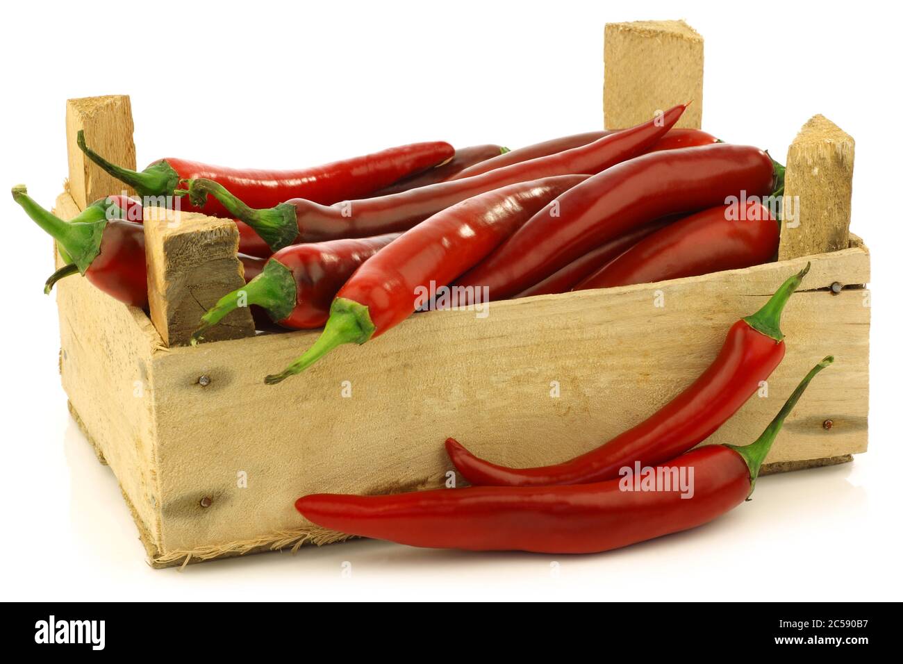 fresh red chili peppers in a wooden crate on a white background Stock ...