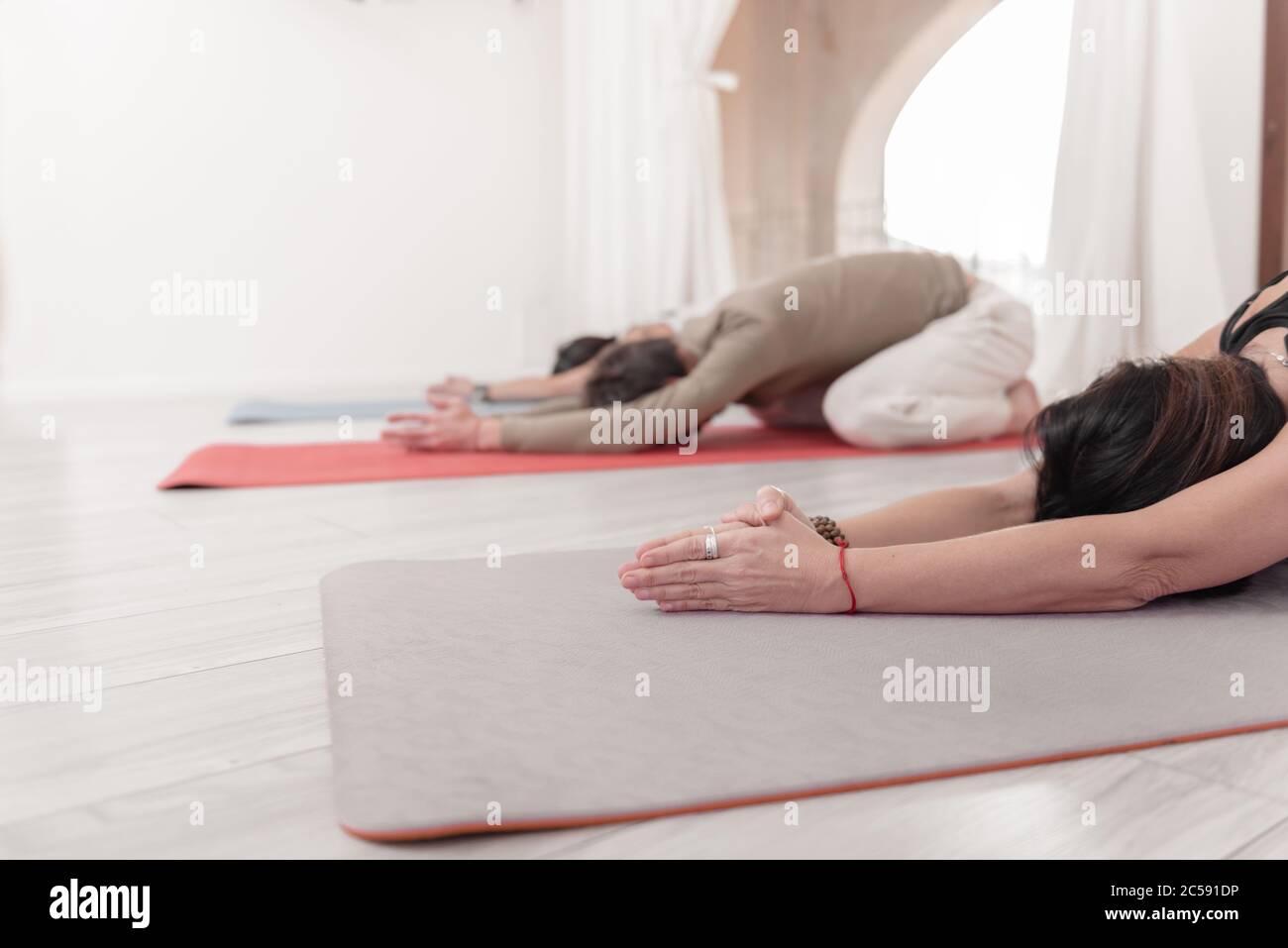 Group of people practicing Yoga. Shashankasana position. Rabbit Pose ...