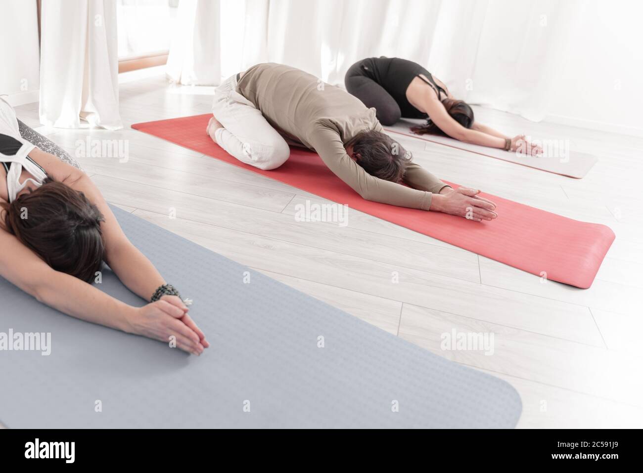 Group of people practicing Yoga. Shashankasana position. Rabbit Pose ...