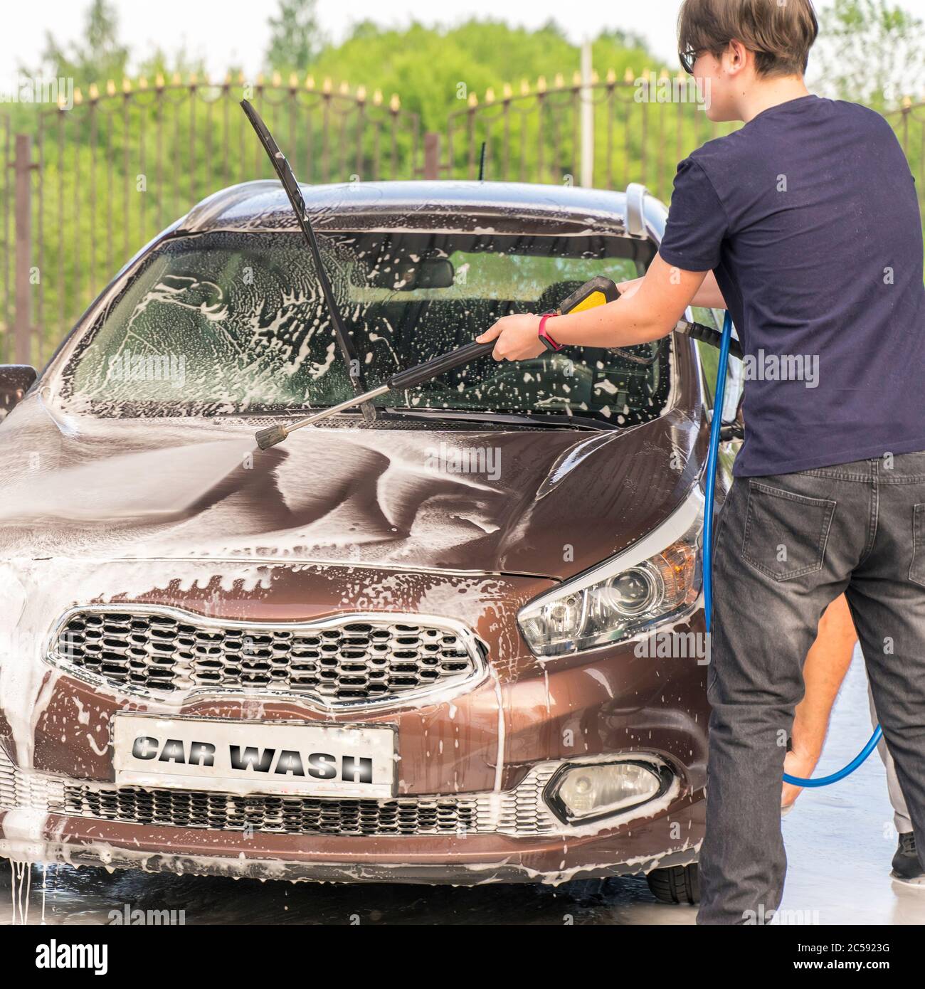 a man washes his car. car wash on car number Stock Photo - Alamy