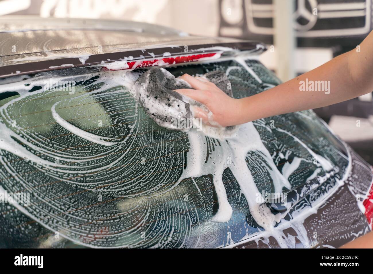 man washes a car with a sponge with foam Stock Photo - Alamy