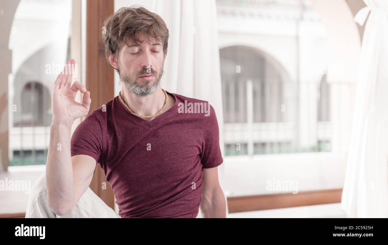 Portrait of bearded man performing yoga in Matsyendrasana pose - lord ...
