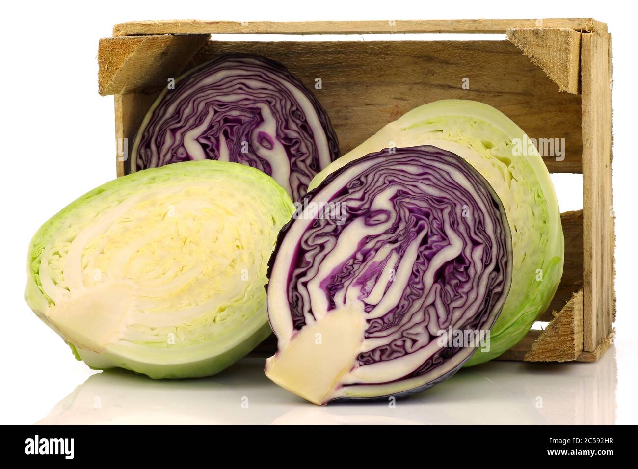 freshly cut red and white cabbage in a wooden crate on a white ...