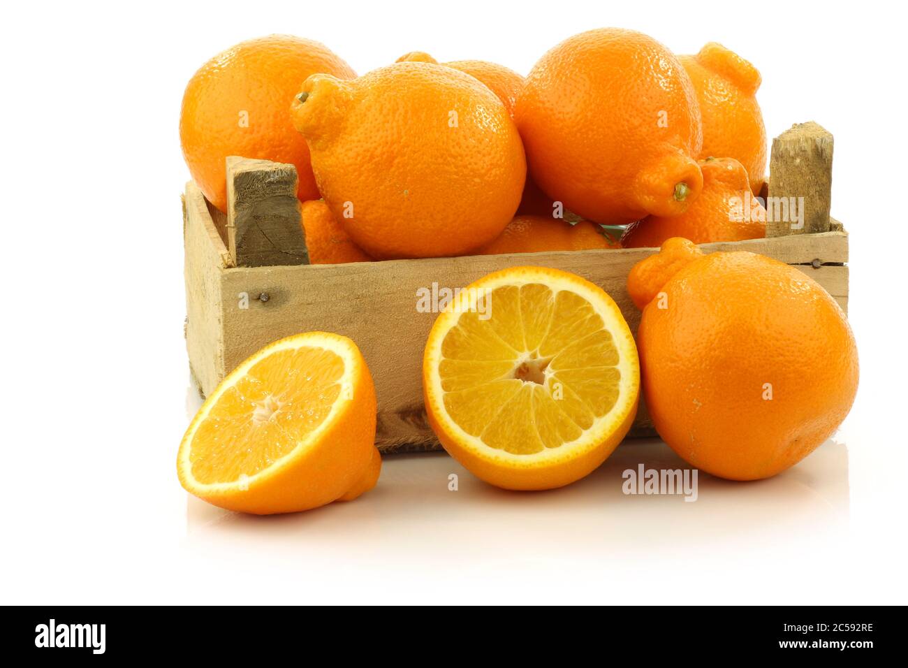 fresh and colorful Minneola tangelo fruit in a wooden crate on a white ...