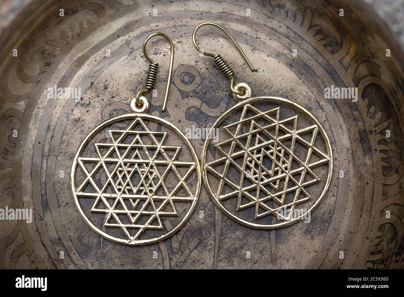 Brass metal boho style Indian sacred geometry earrings Stock Photo - Alamy