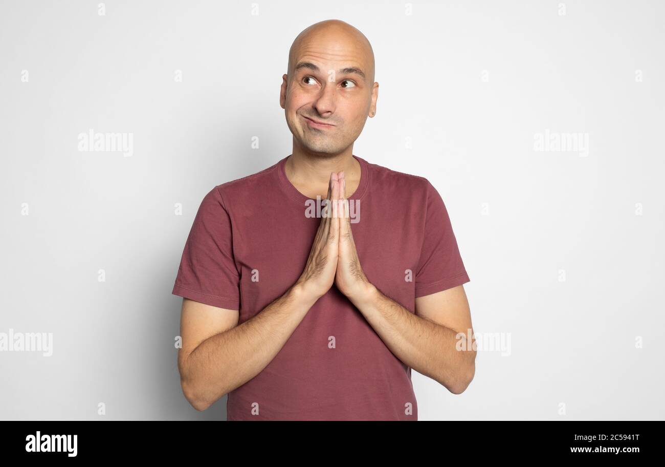 portrait of a middle aged bald man smirking looking up isolated on grey ...
