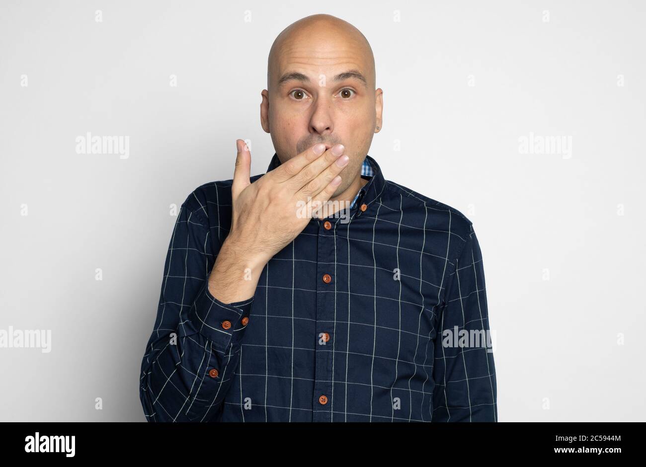 Shocked bald man looking at camera. Isolated on grey studio background ...
