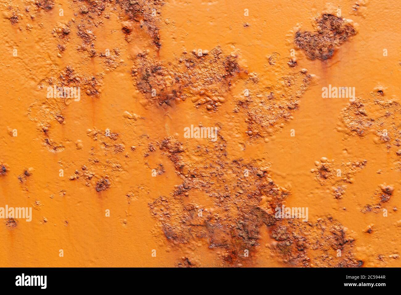 orange painted hull of a ship with rust coming through Stock Photo - Alamy