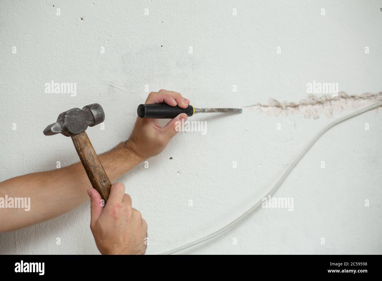 Repair of the premises. A man makes a ditch for laying cable into the ...