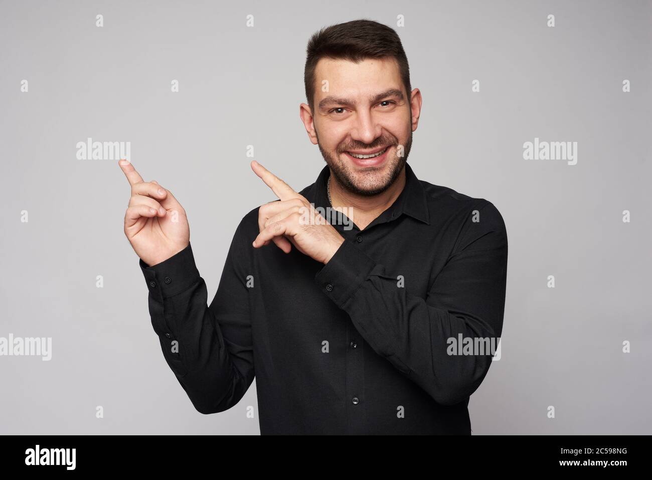 Bearded handsome man pointing fingers away at copy space. Isolated ...