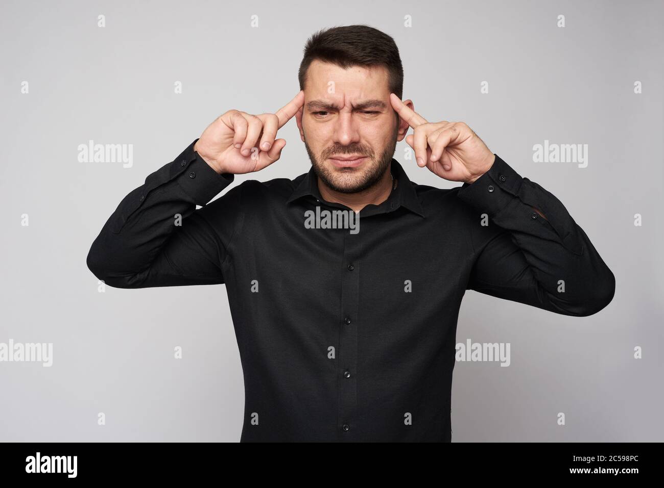 Young bearded man thinking too hard, solving a difficult problem. Angry ...