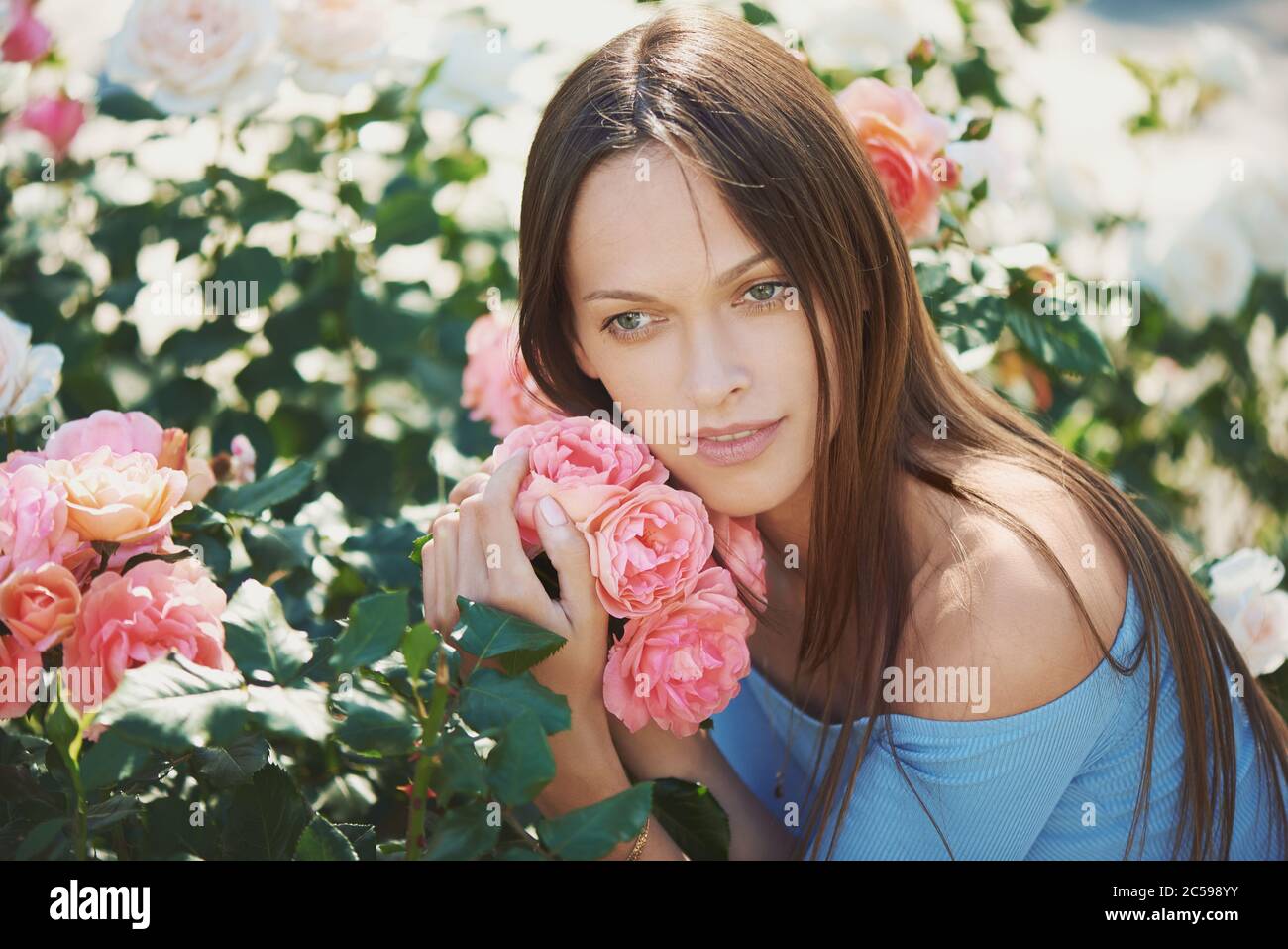 Beautiful girl with rose flowers in the city park Stock Photo - Alamy
