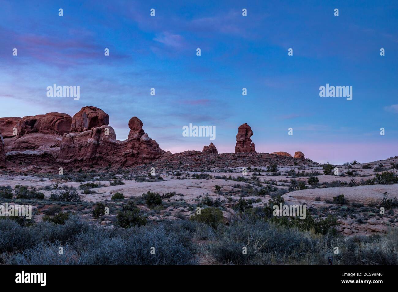 Colorful blue and purple sky over various sandstone rock formations ...