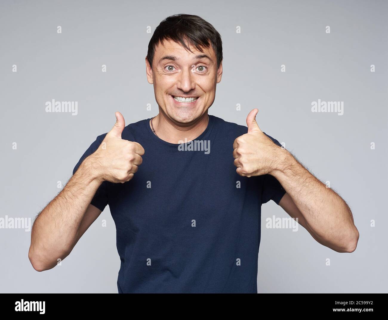 cunning man shows thumbs up gesture. Isolated on grey Stock Photo - Alamy