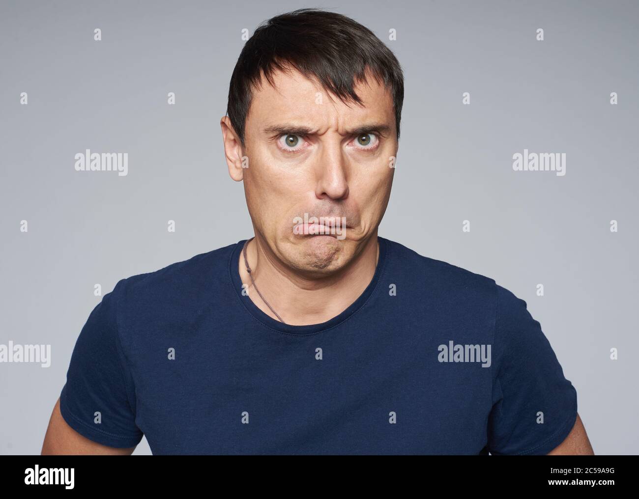 doubtful young man face isolated on grey studio background Stock Photo ...