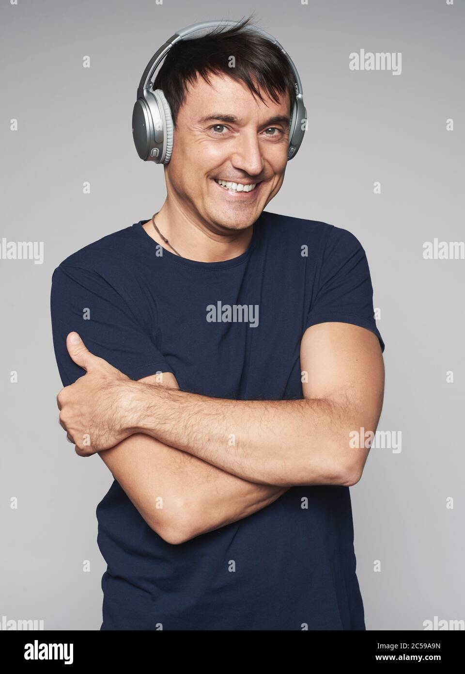 Happy middle aged man with headphones. Listening to music. Studio shot ...