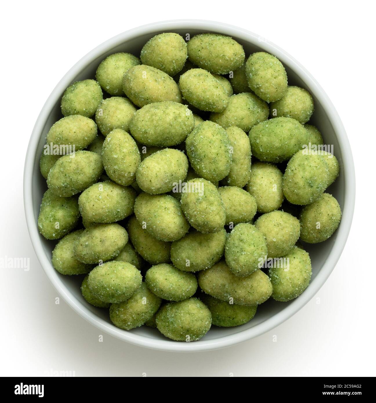 Wasabi coated peanuts in a white ceramic bowl isolated on white. Top ...