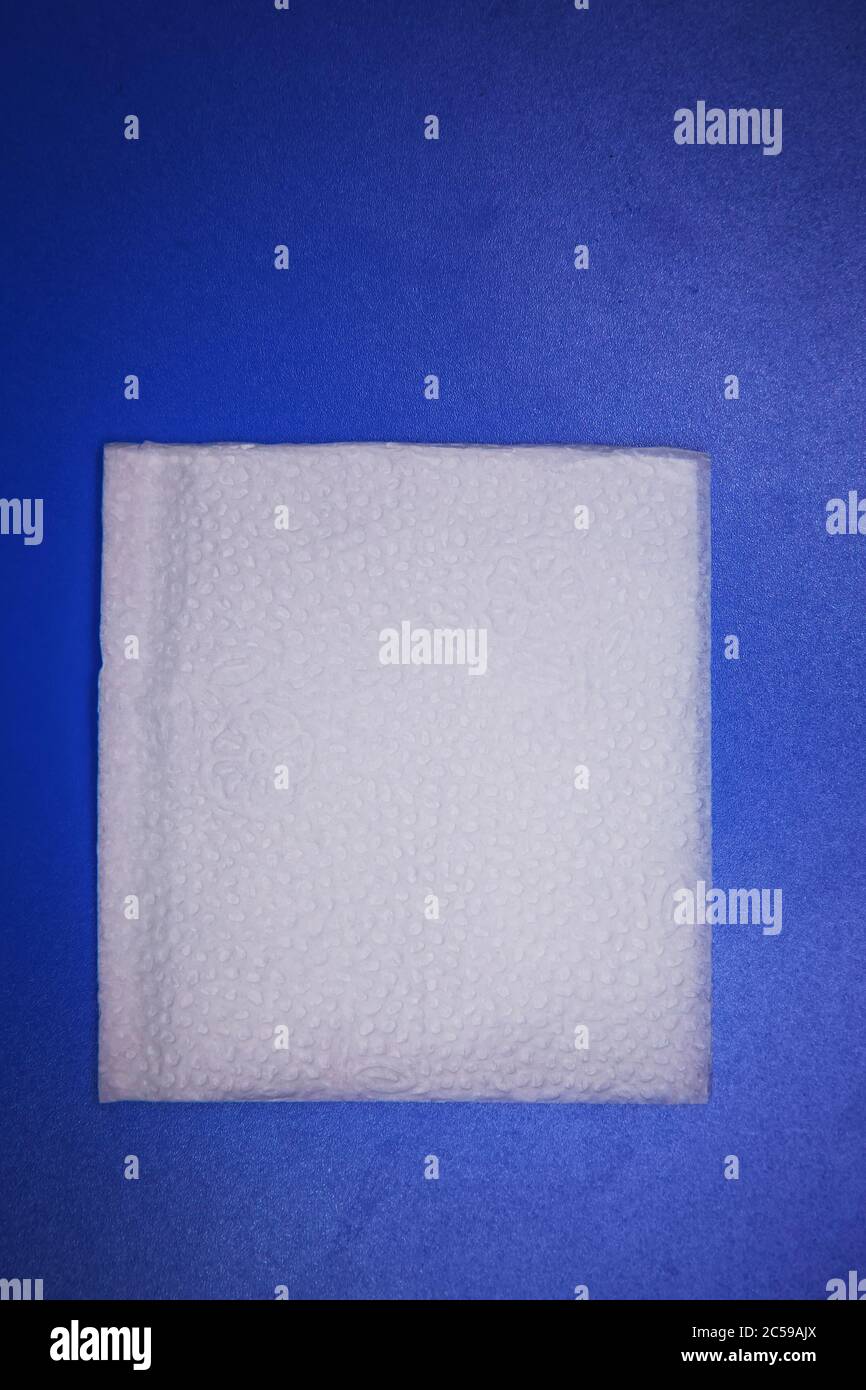 Blank paper napkin isolated on blue background with copy space . White ...