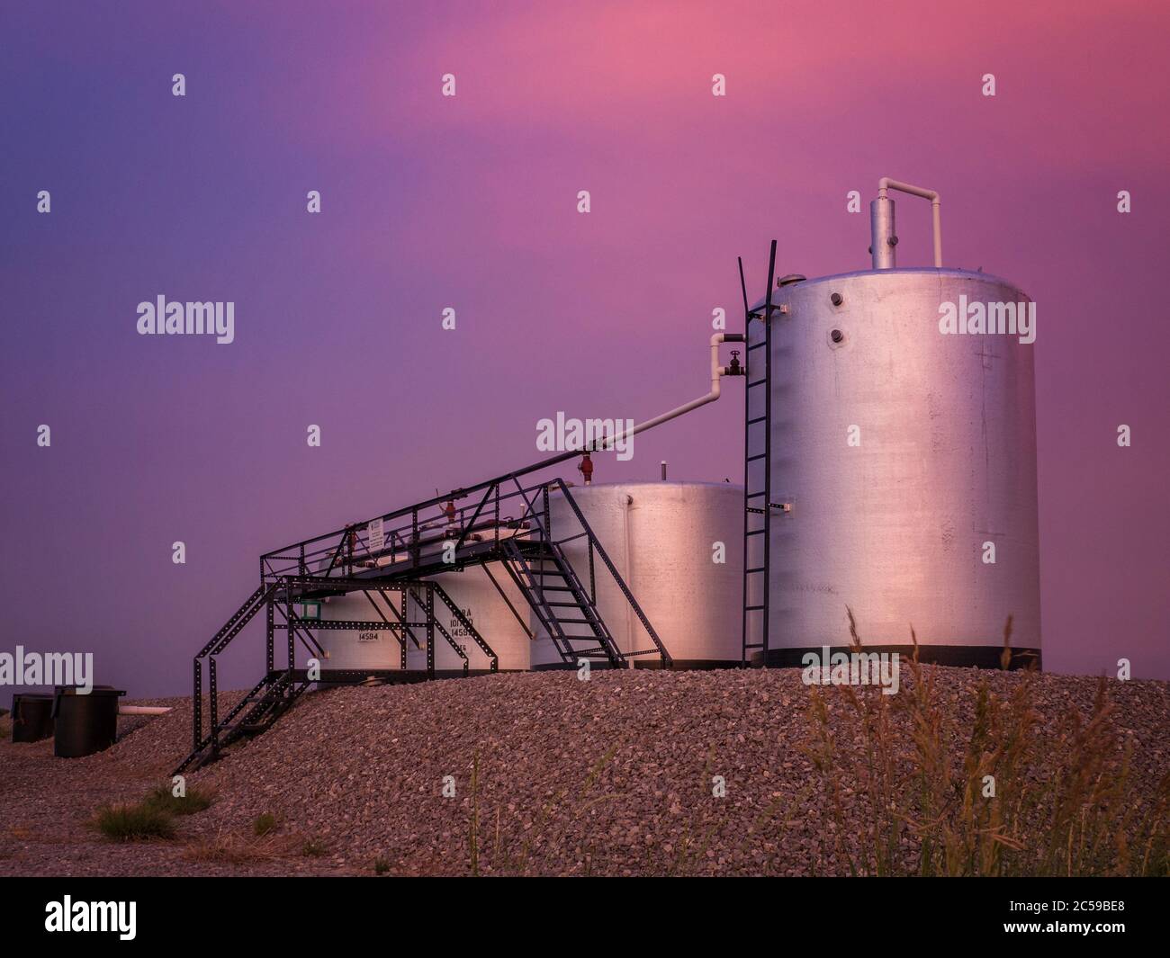 Oilwell at sunset with an purple and pink sky Stock Photo - Alamy