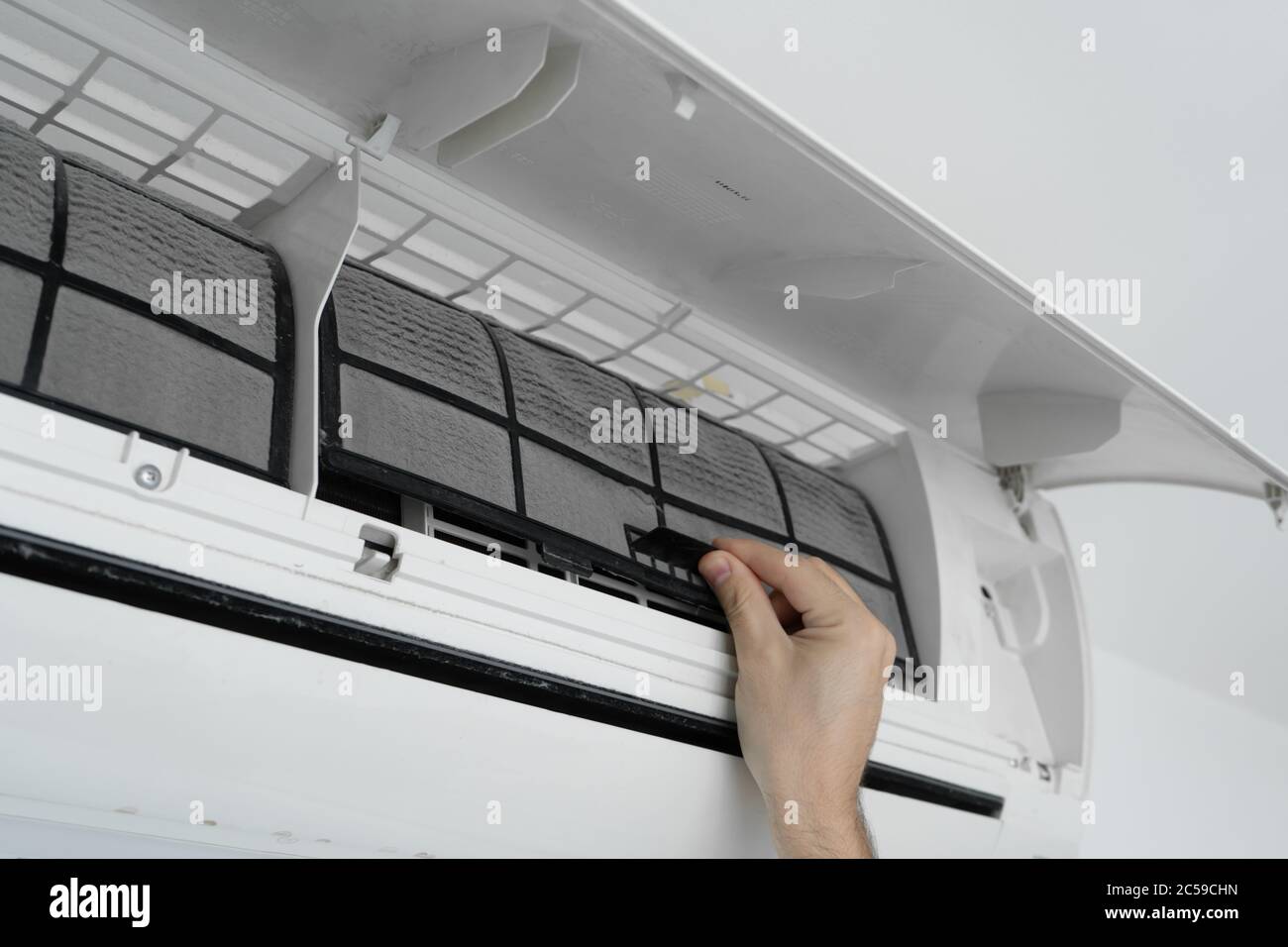 The guy cleans the filter of the home air conditioner from dust. Very ...