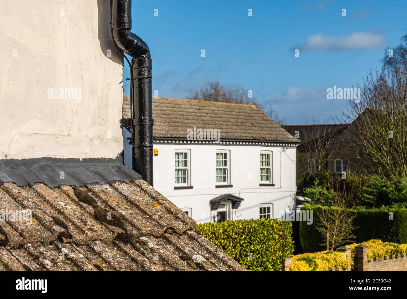 Shallow focus of part of a cottage roof and guttering in the foreground ...
