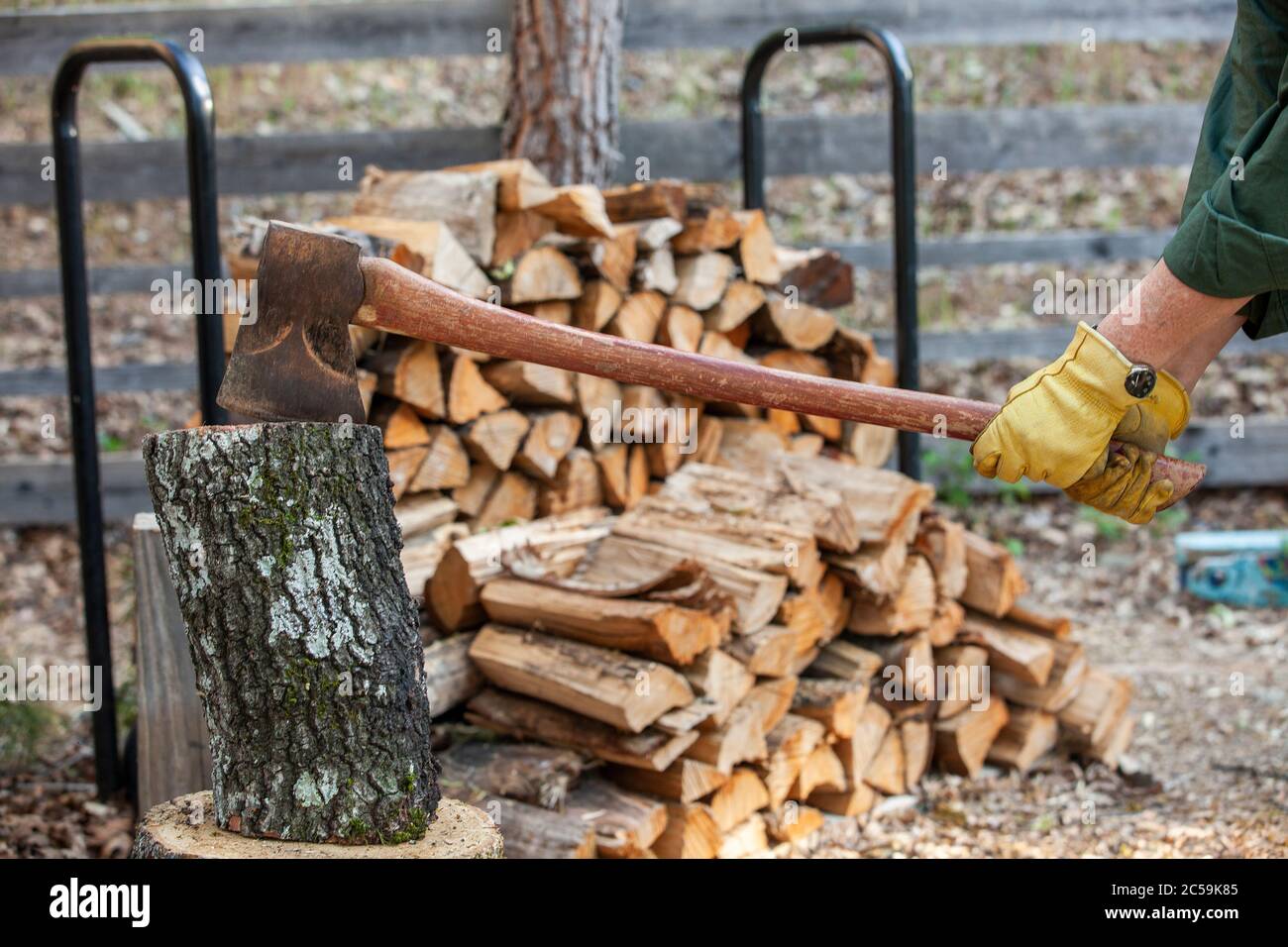 Person splitting log for firewood with Ax Stock Photo - Alamy