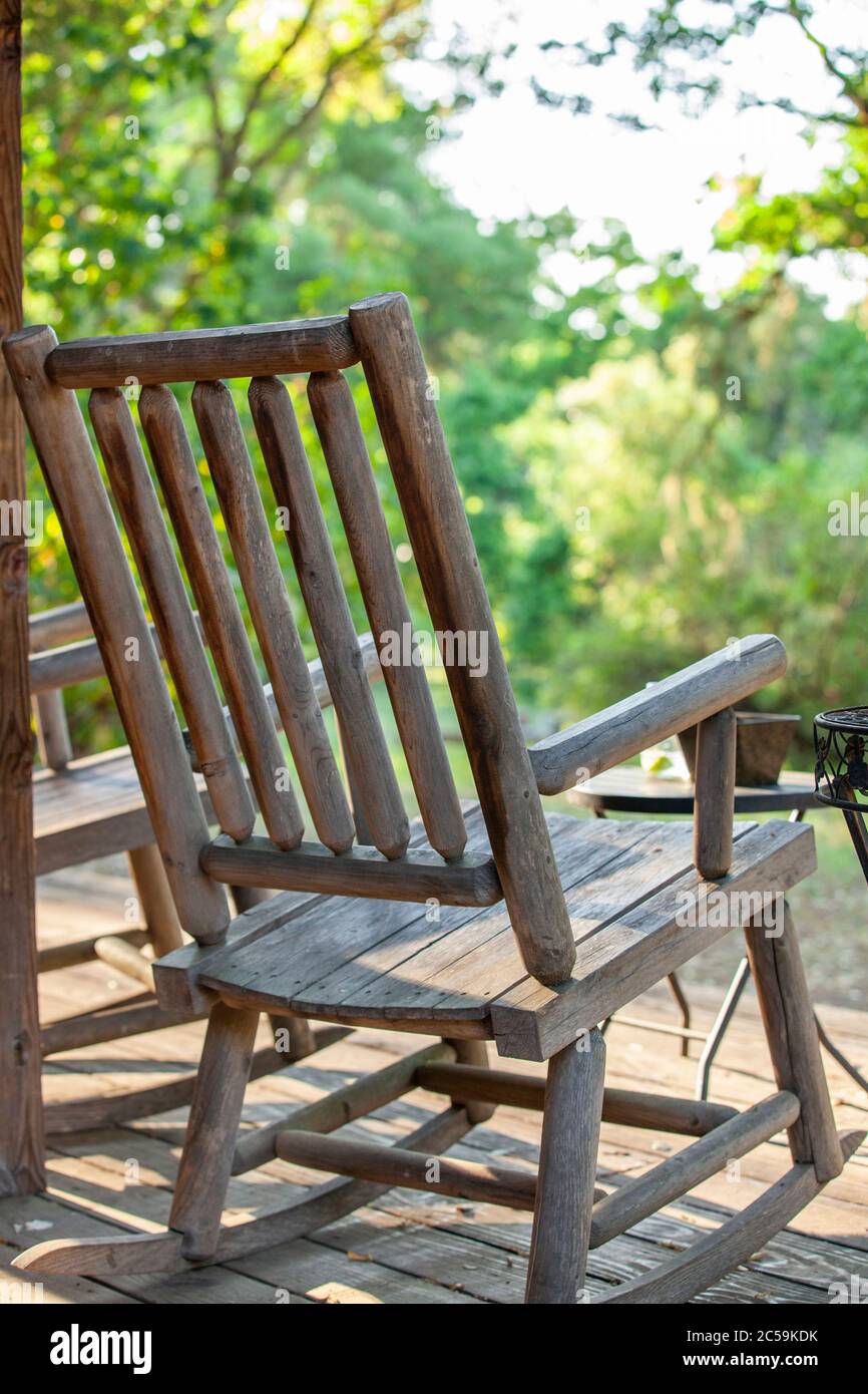 Rocking chair on front porch of log cabin Stock Photo - Alamy