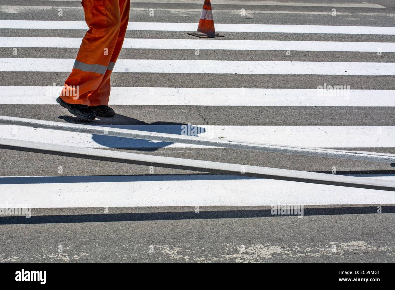 Workers are painting a pedestrian crossing in a city street Stock Photo ...