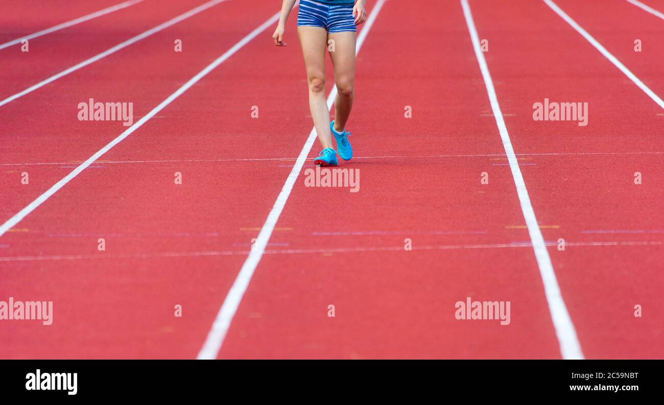 Sport and fitness runner woman athlete on red run track with blue ...