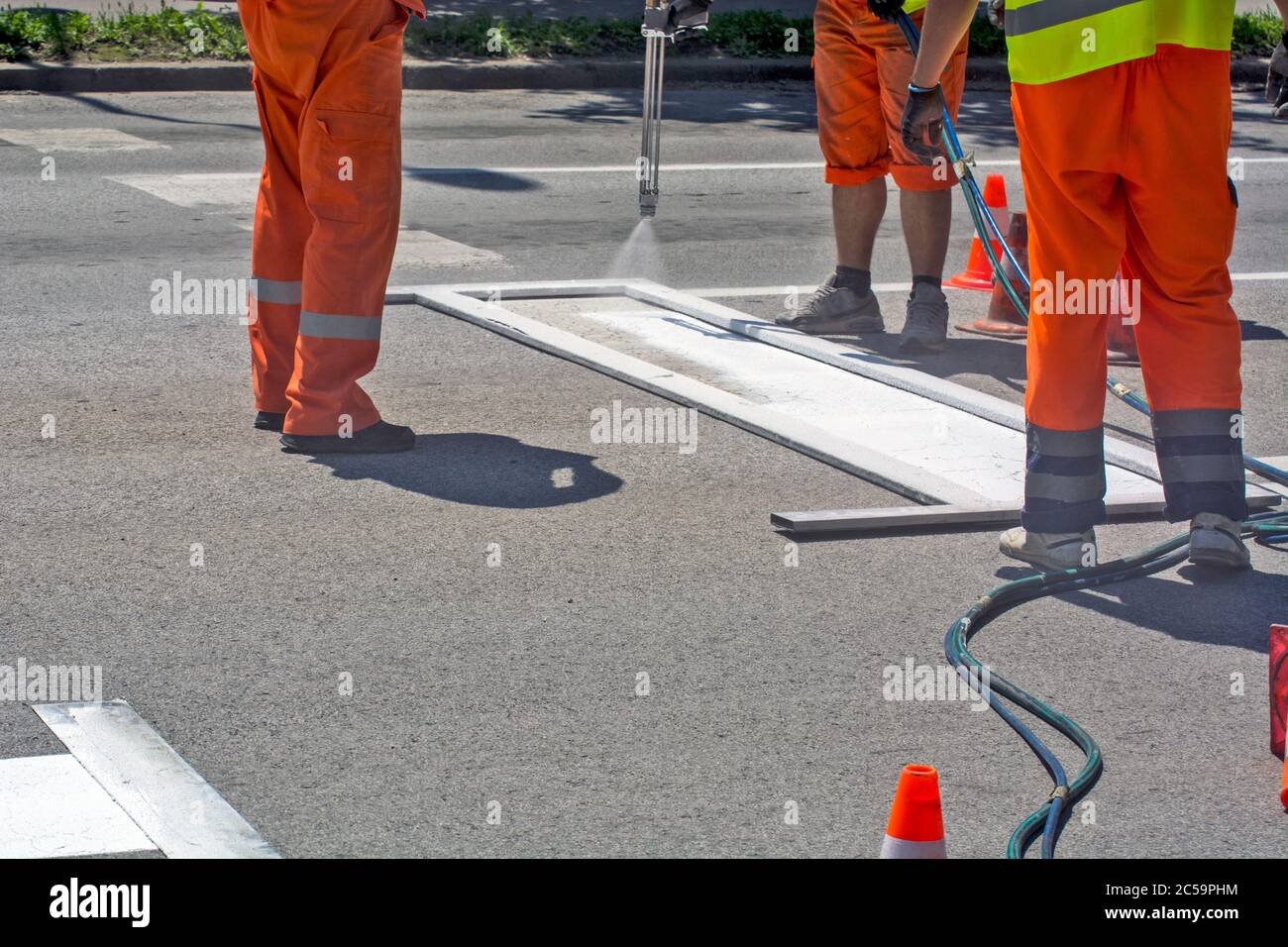 Workers are painting a stop line in a city street Stock Photo - Alamy