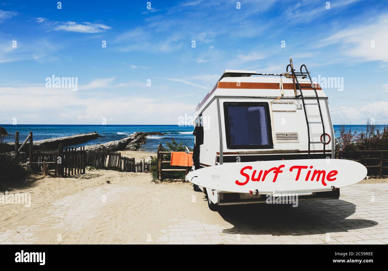 Rear view of vintage camper parked on the beach against a beautiful ...