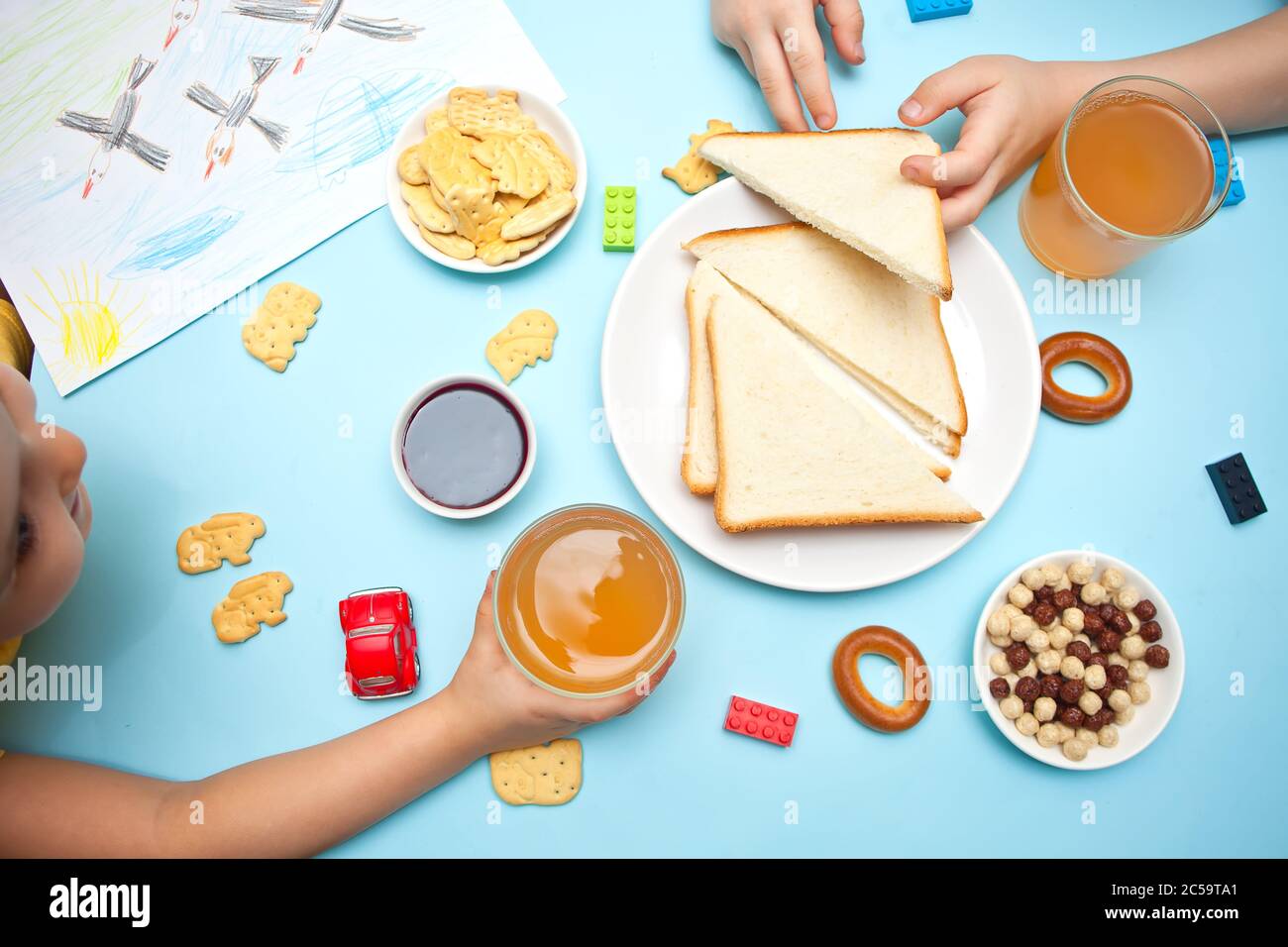 Two child kids eating snacks sandwiches and cookies and drinking apple ...