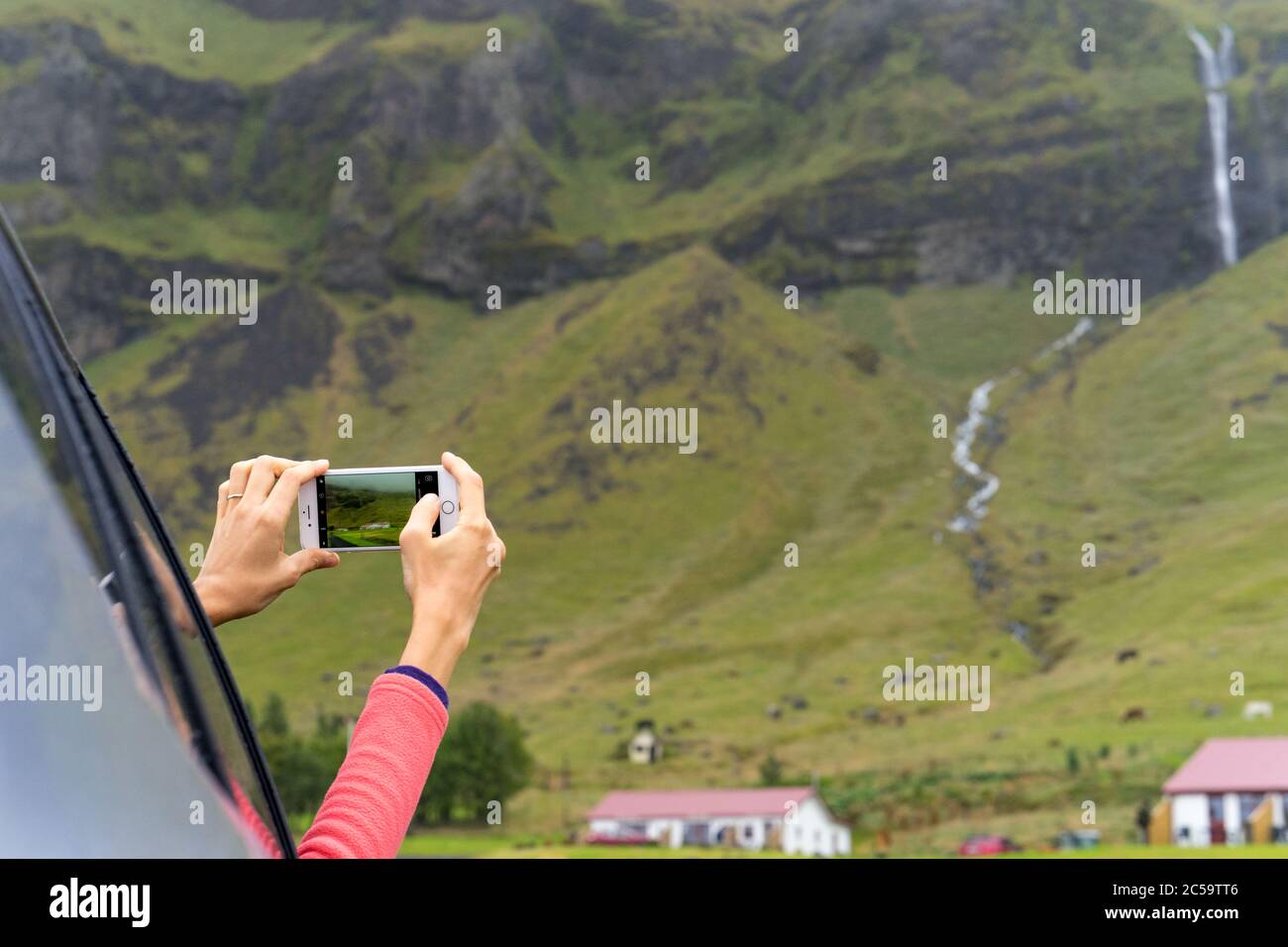 Snapping landscape waterfall from the car in Iceland on the phone Stock ...