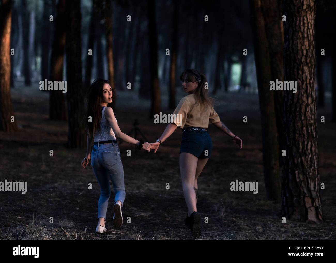 two girls in the forest flee terrified Stock Photo - Alamy
