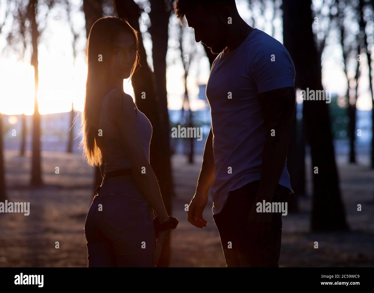 couple in the forest, at sunset, backlight Stock Photo - Alamy