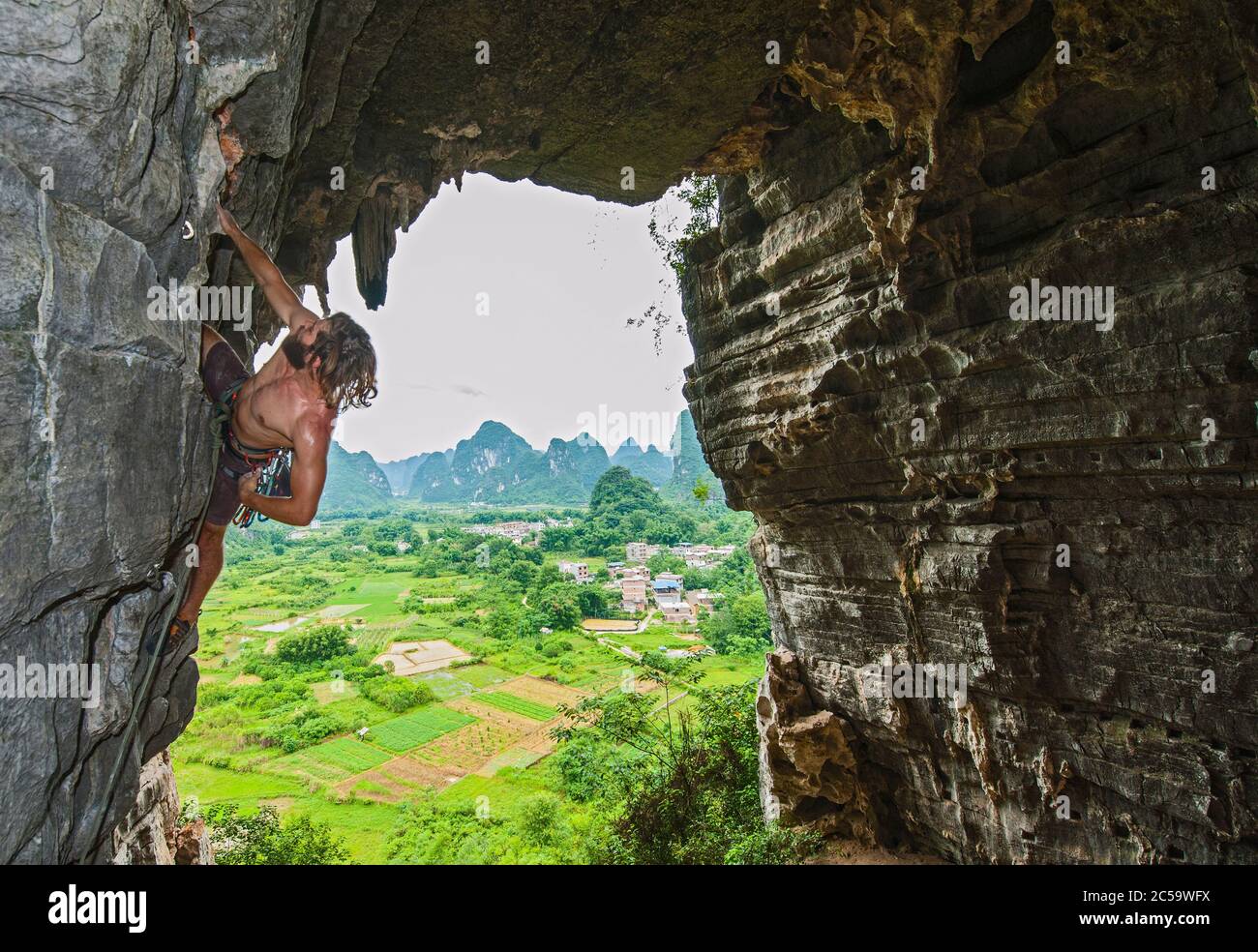 young male climber climbing at treasure cave in Yangshuo, China Stock ...
