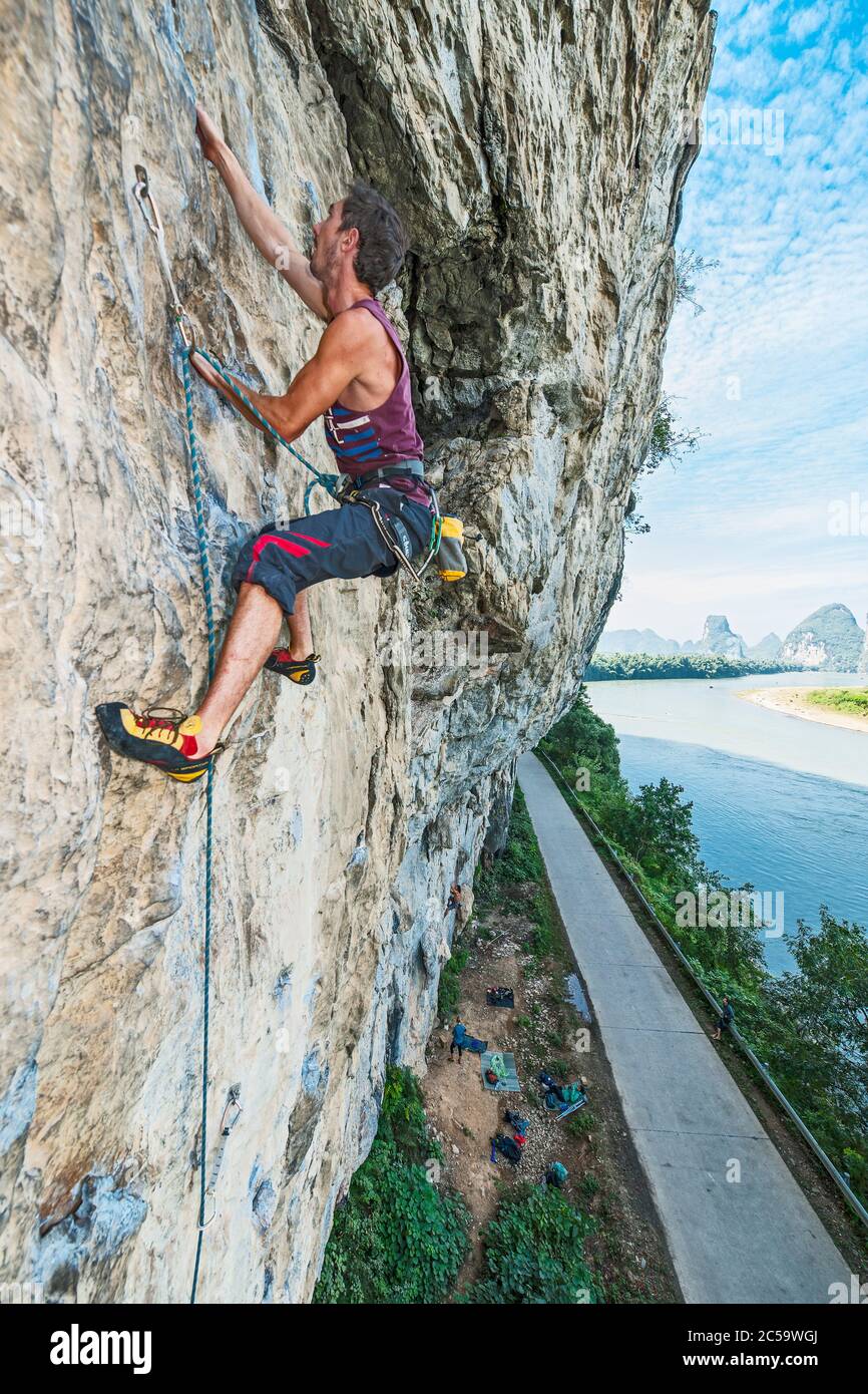 young man climbing steep rock face in Yangshuo / China Stock Photo - Alamy