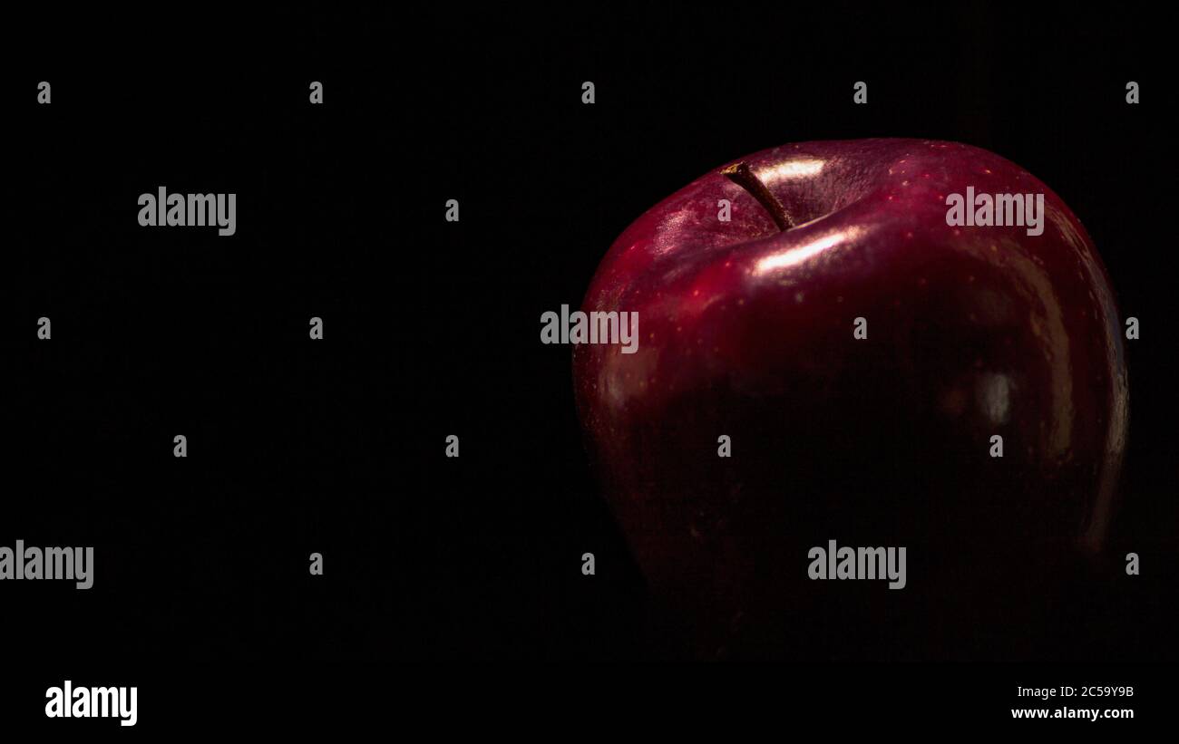 Closeup of a dark red shiny apple on a black background Stock Photo - Alamy