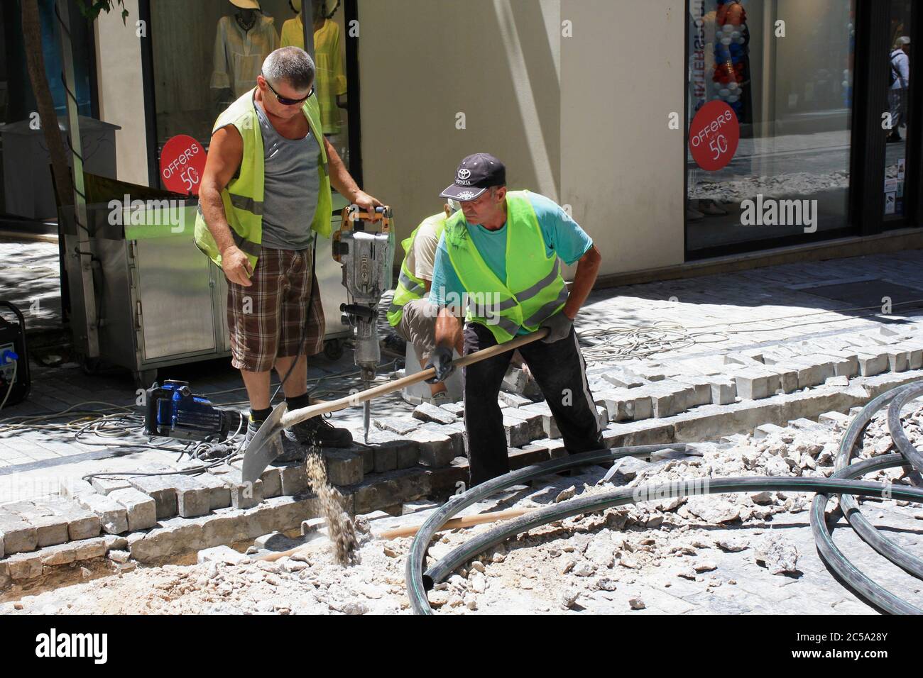 Greece, Athens, June 28 2020 - Construction workers digging and paving ...