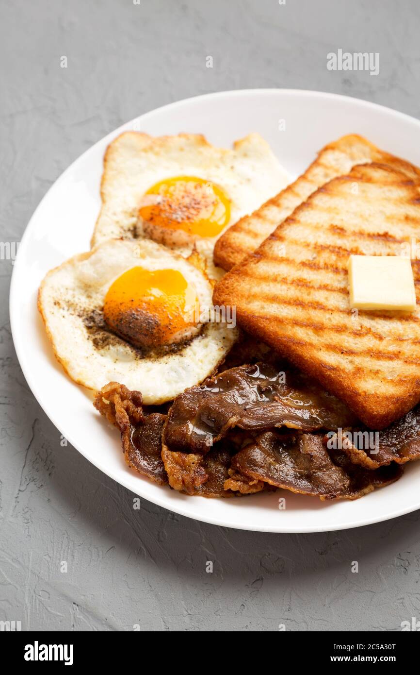 Homemade Healthy Sunnyside Eggs Breakfast on a white plate on a gray ...