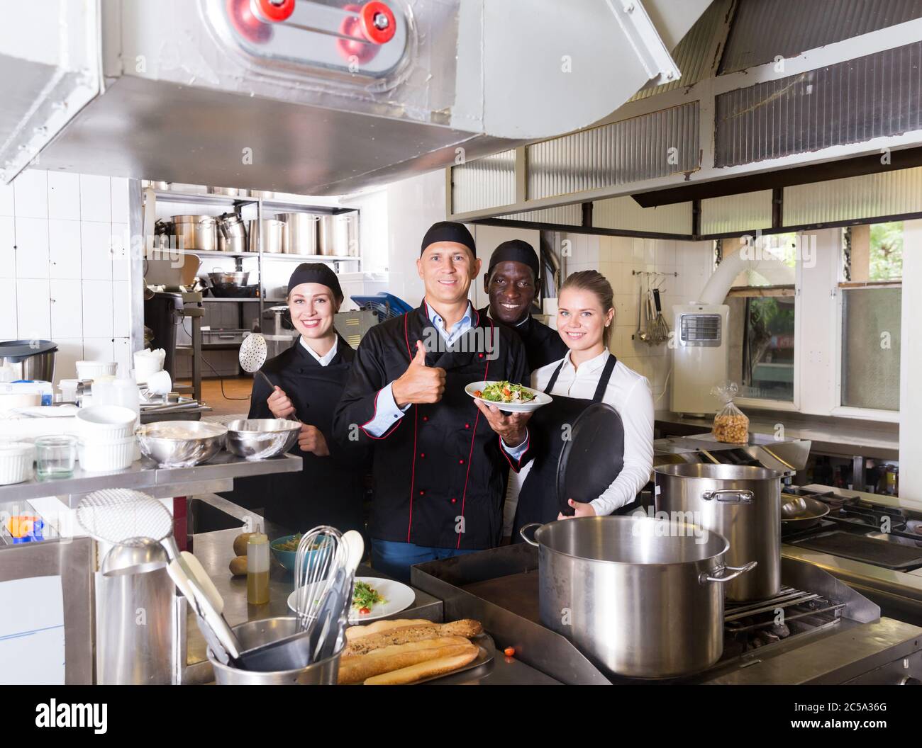 Successful multinational team of restaurant staff standing together in ...